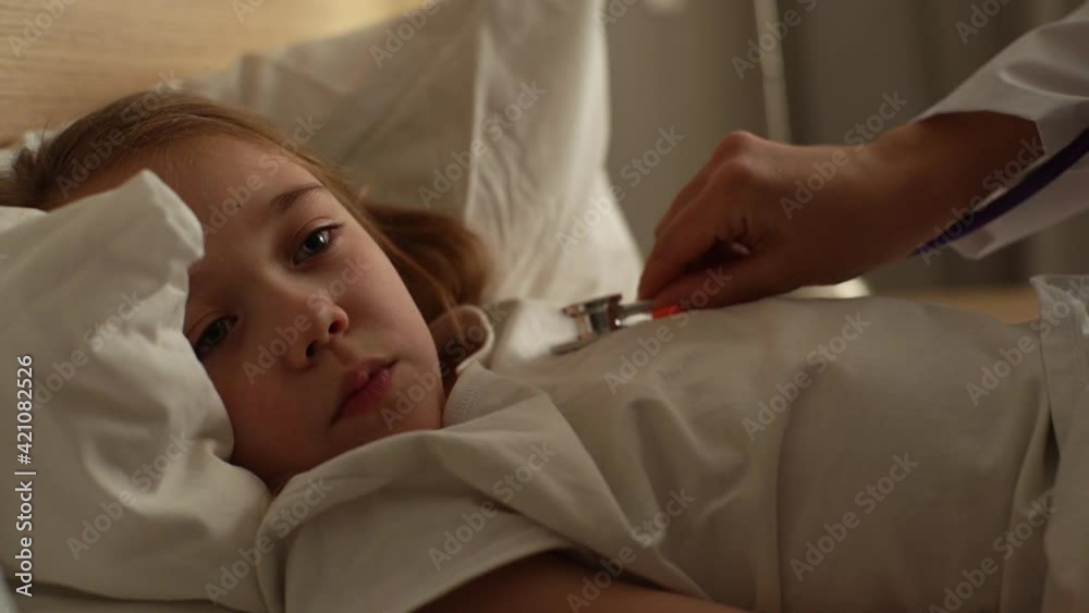 Close-up view of professional female doctor examining little upset sick ...