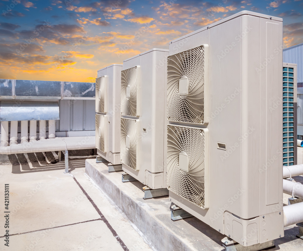 Condenser unit or compressor on roof of industrial plant building with ...