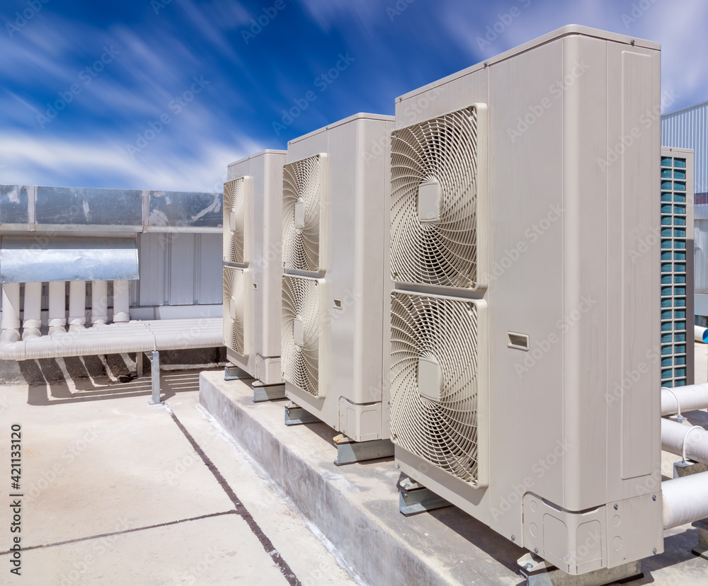 Condenser unit or compressor on roof of industrial plant building with ...