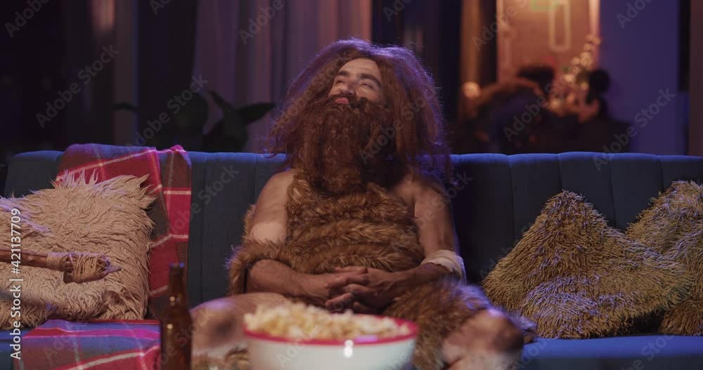 Portrait of funny ancient prehistoric primitive human in animal fur ...