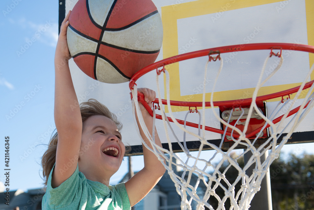 Close up image of kid basketball player making slam dunk during ...