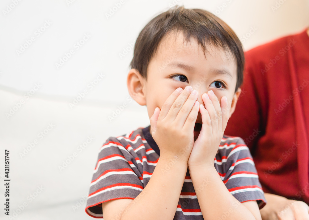 Asian toddler little boy covering face with both hands being afraid of ...