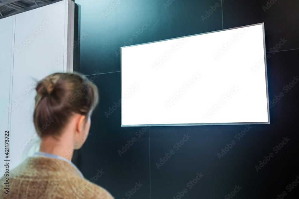 Woman looking at blank digital interactive white display wall at ...
