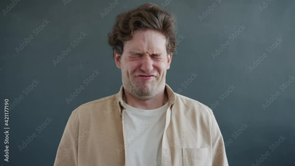 Portrait of silly guy making funny faces showing tongue fooling around ...