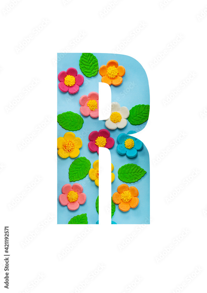 The letters R of the English alphabet is cut out of flowers on a blue ...