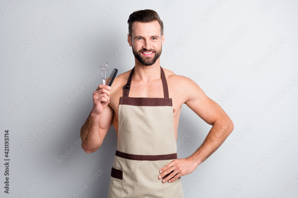 Portrait of attractive content fit cheerful guy wearing apron holding ...