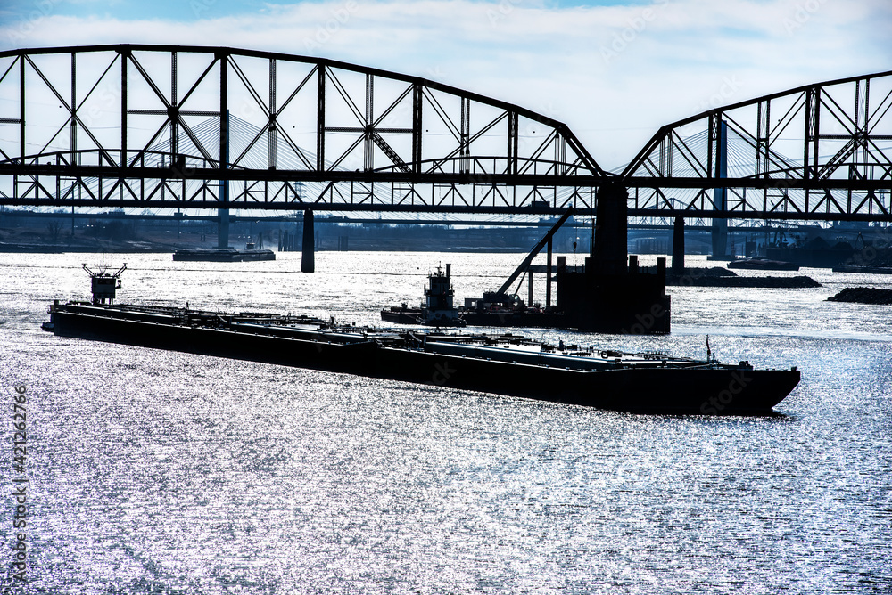 Towboat pushing dry bulk cargo barge under bridges up Mississippi River ...