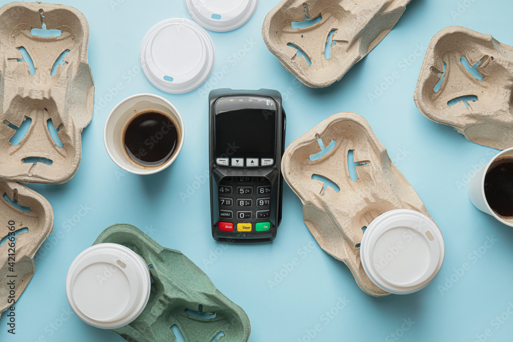 Payment terminal with takeaway cups on color background Stock Photo ...