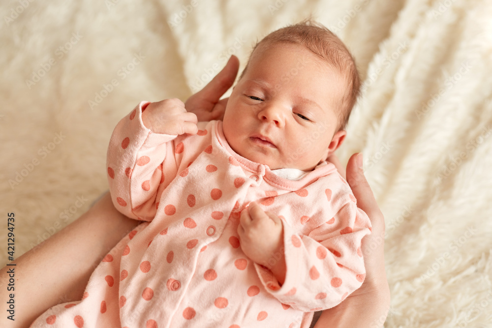 Newborn baby girl asleep in mother's arm on background of blanket ...