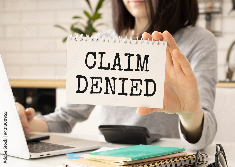 Business woman shows a card with text Claim Denied . Injury claim ...