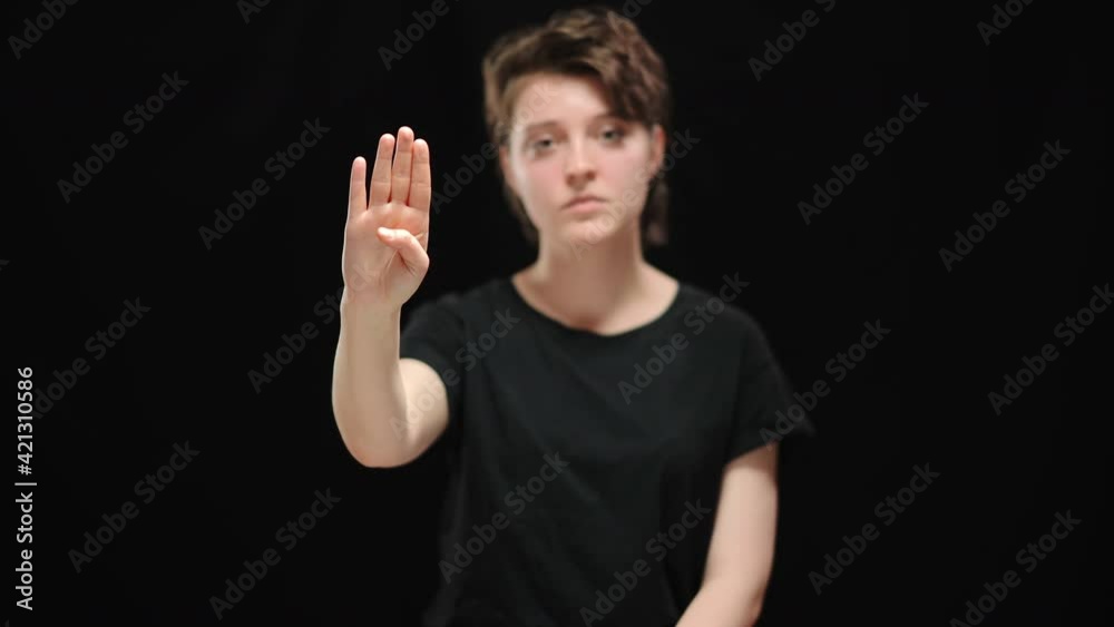 Palm at camera with tuck thumb and blurred sad woman at black ...