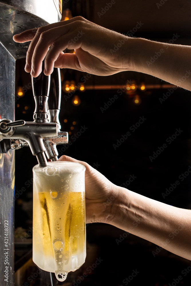 Bartender hands pouring a cold draft beer into a mug , black background. Pilsen Stock Photo ...