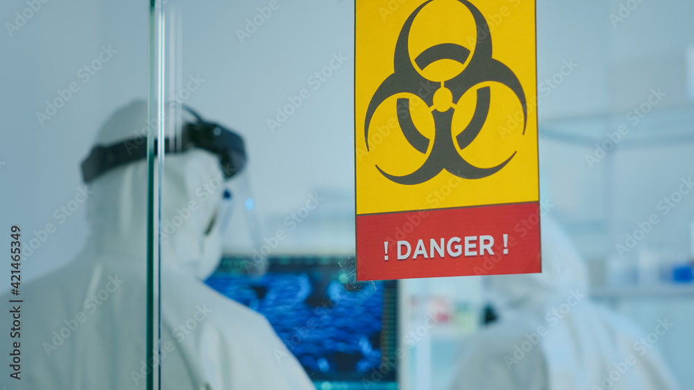 Team of scientists in coverall researching virus mutations working in ...