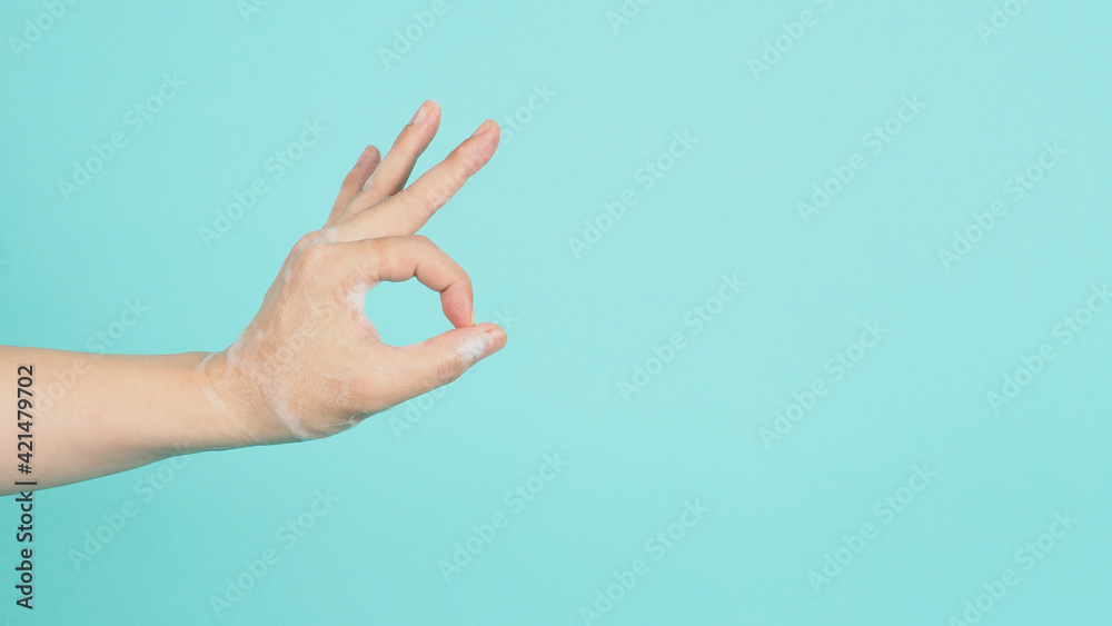 Hand is do a okay hand sign and have foam soap bubbles on a green mint ...