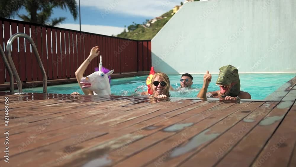 Crazy friends doing pool party wearing bizarre mask - Young people ...