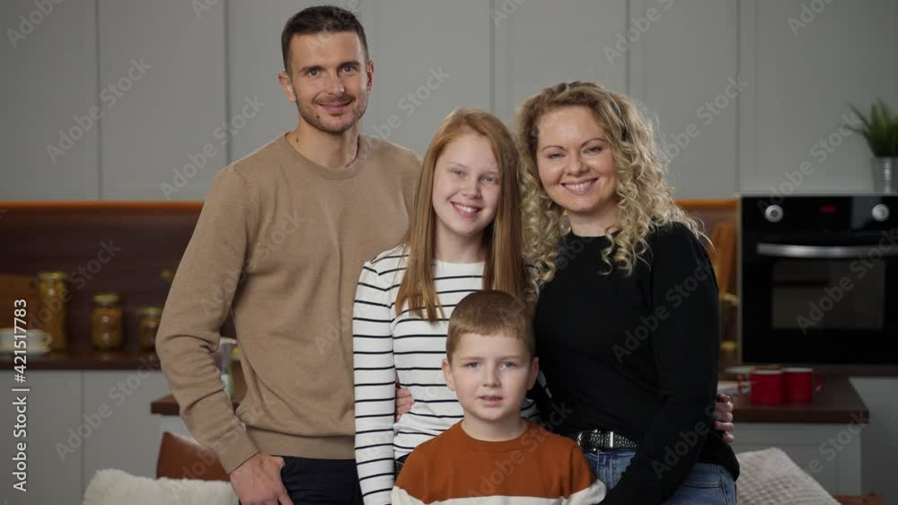 Attractive married couple and two cute ginger children posing on camera ...