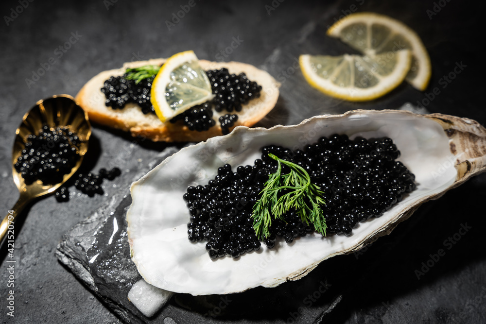 Black caviar in oyster shell on black slate background Stock-Foto ...