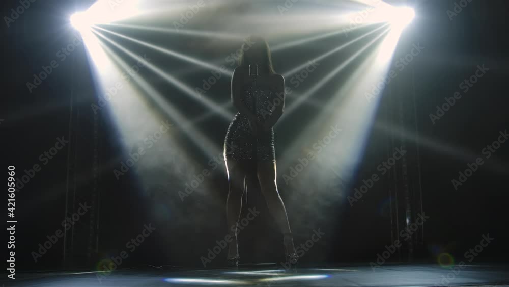 Bottom view is silhouette of long legged female vocalist in short shiny ...