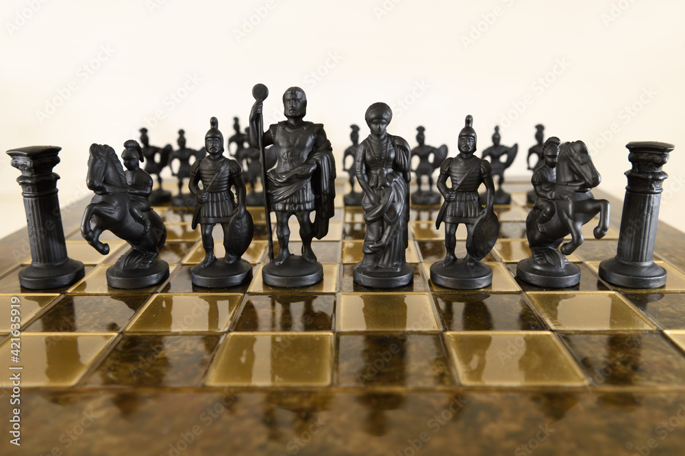 Black metal chess pieces on chessboard with pawns behind castle knight ...