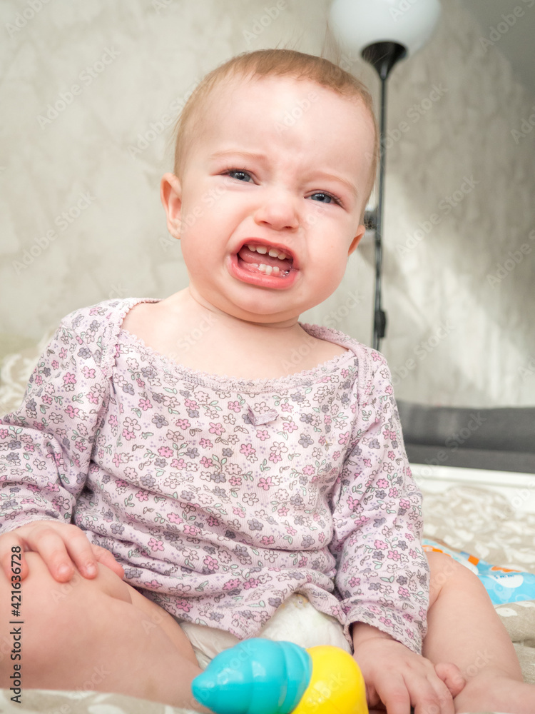 Foto de Beautiful little girl of ten months crying and throwing a ...