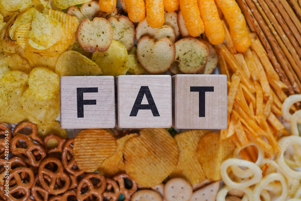 The word FAT is made of wooden cubes on a background of different ...