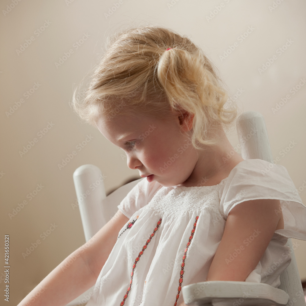 Sad young girl sitting in rocking chair Stock Photo | Adobe Stock