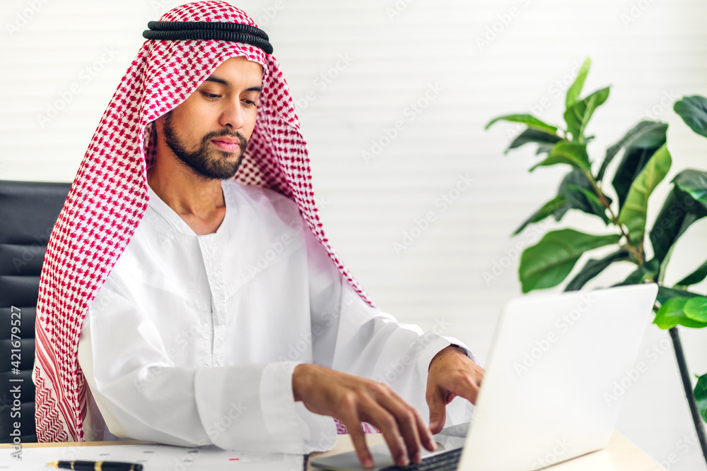 Handsome confident arab businessman working and looking at technology ...