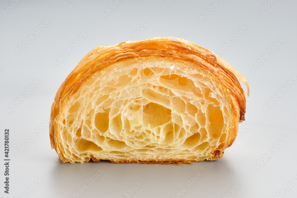 Fresh baked croissant unfilled cutaway on a light grey backgroundon ...