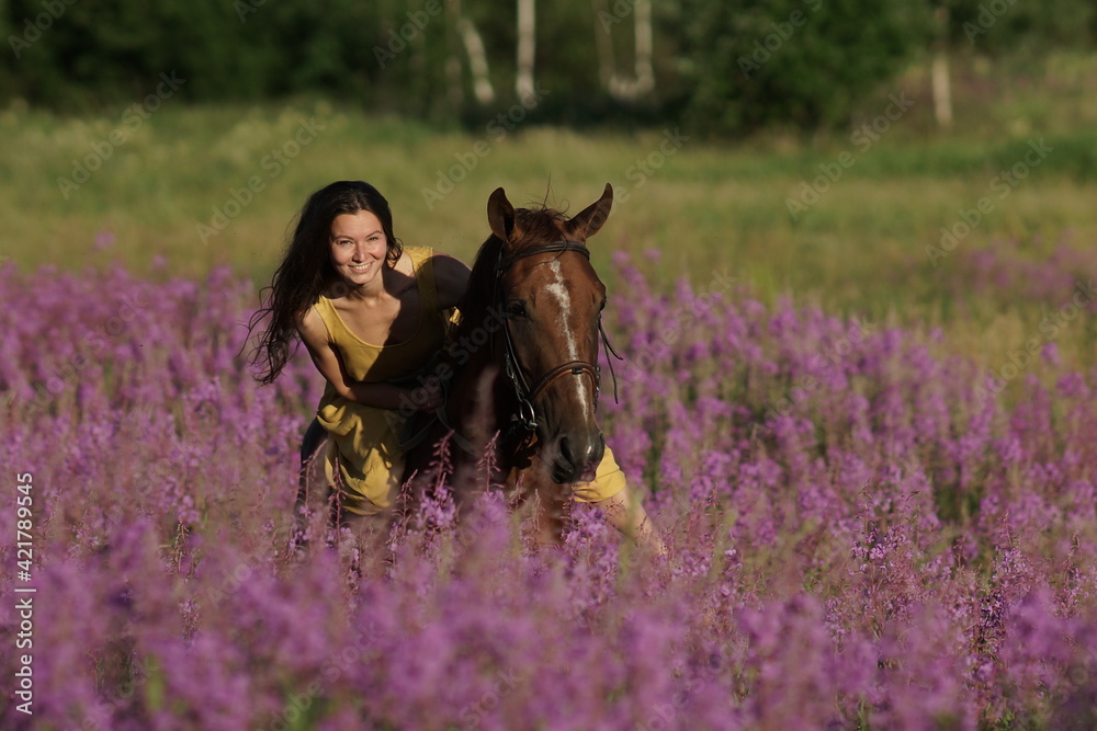 Beautiful woman with long hair in yellow dress riding bareback a brown ...