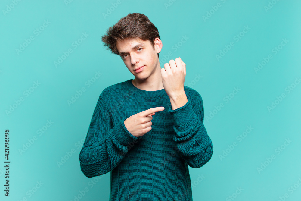 young boy looking impatient and angry, pointing at watch, asking for ...