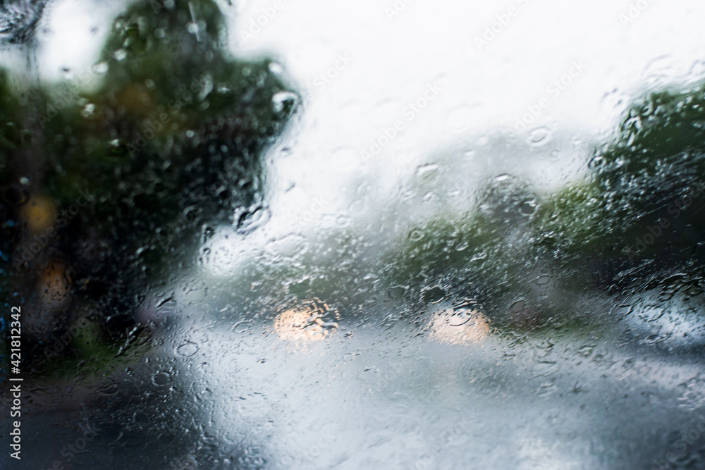 Blurred defocused image of heavy torrential rain through the windscreen ...