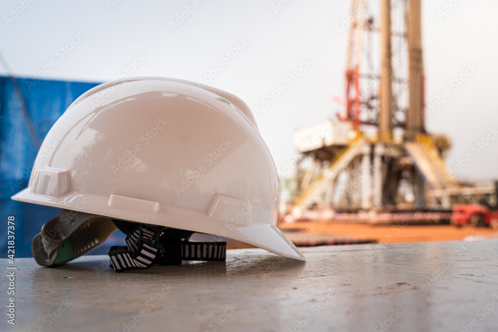 A white safety helmet in placed on table during the worker is taking a ...