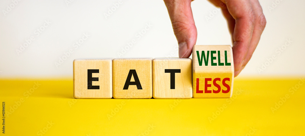 Eat well or eat less symbol. Businessman turns a cube and changes words ...
