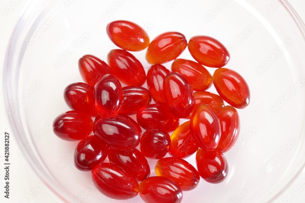Krill oil capsules. Red capsules with krill oil in a glass transparent ...