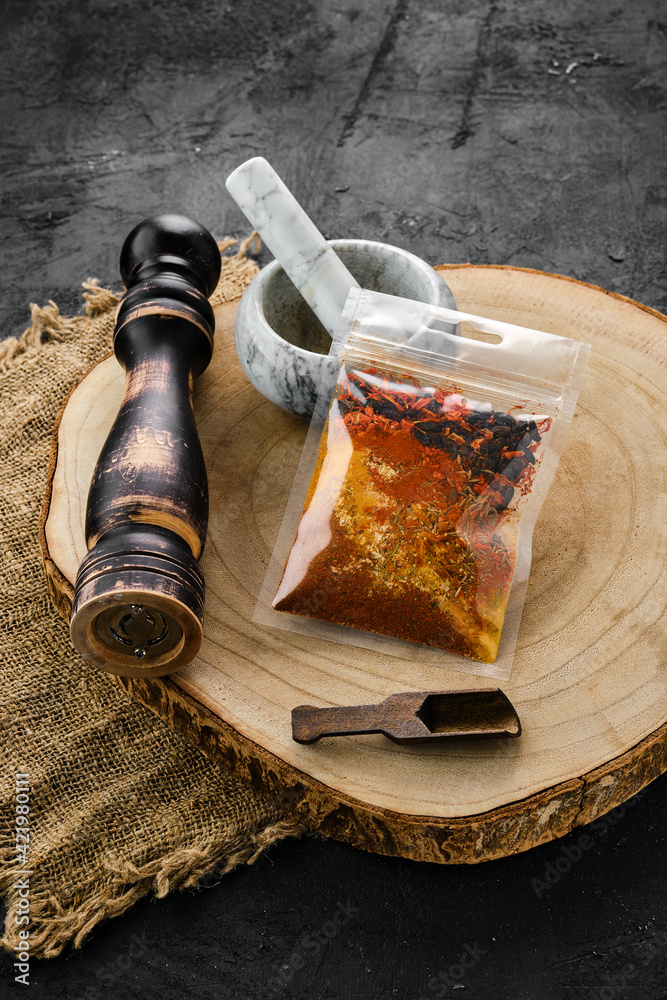 Wooden cross section with a set of spices for pilaf in plastic package ...