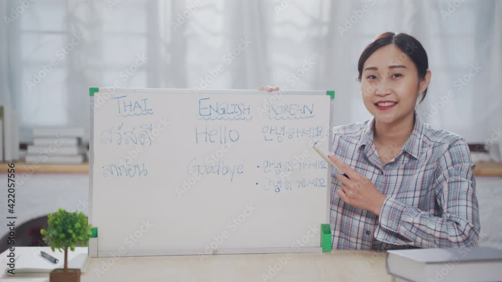 Young adult Asian female teacher sitting and using whiteboard teaching ...