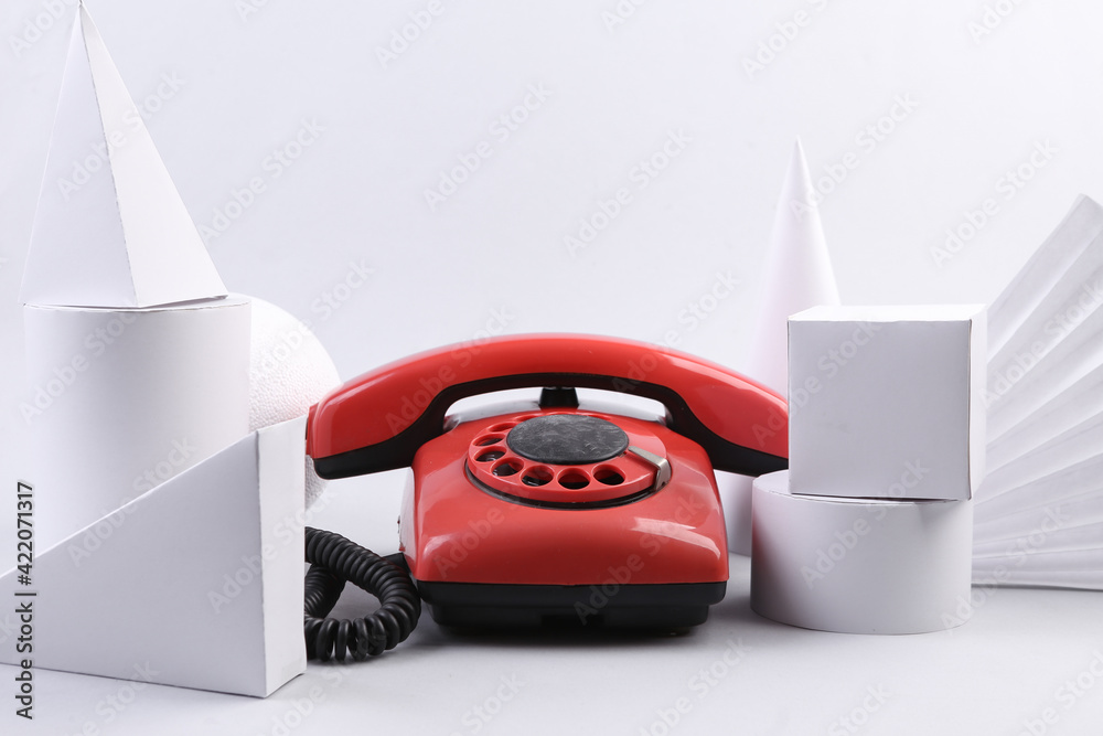 Retro rotary telephone and white geometric shapes on a white background ...