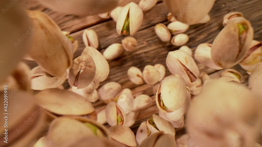 Super Slow Motion Shot of Fresh Roasted Pistachio Nuts Falling on ...