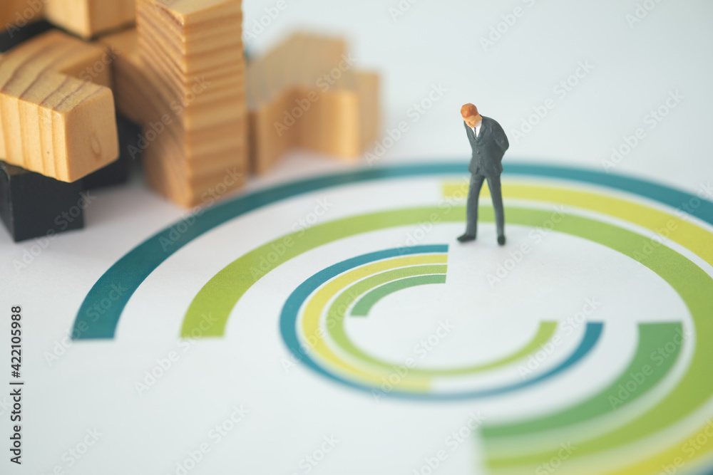 Miniature businessman standing on the circle chart paper and look at ...