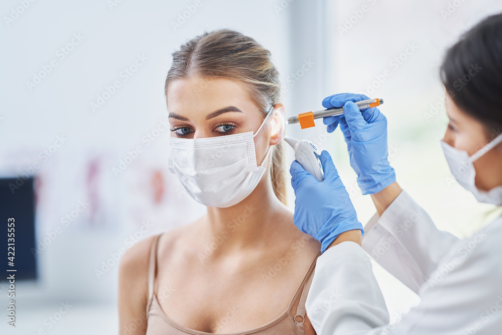 ENT specialist checking up on her female patient Stock Photo | Adobe Stock