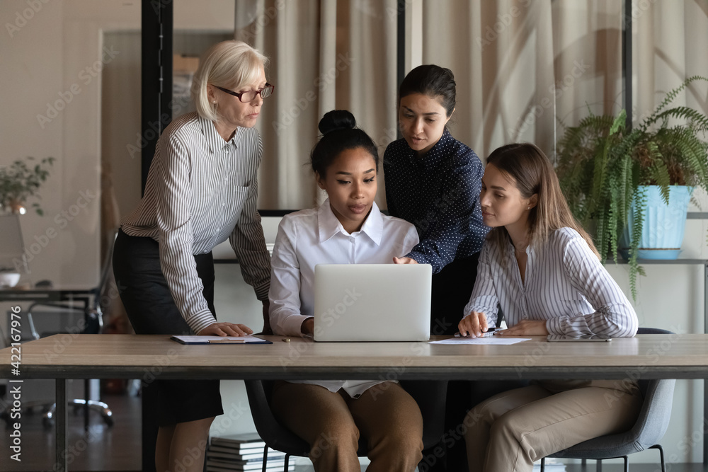 Successful multiethnic businesswomen work together on laptop brainstorm ...