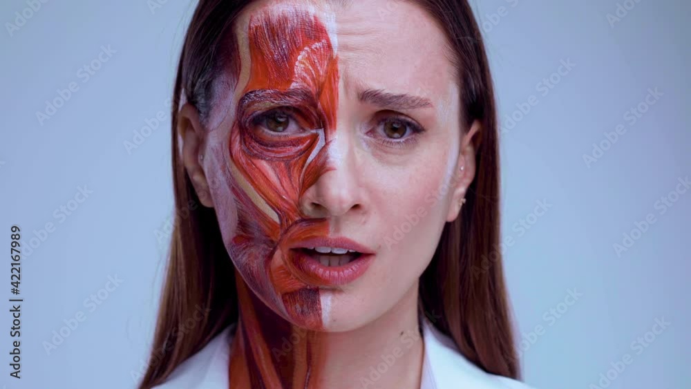 Young woman with half of face with muscles structure under skin. Model ...