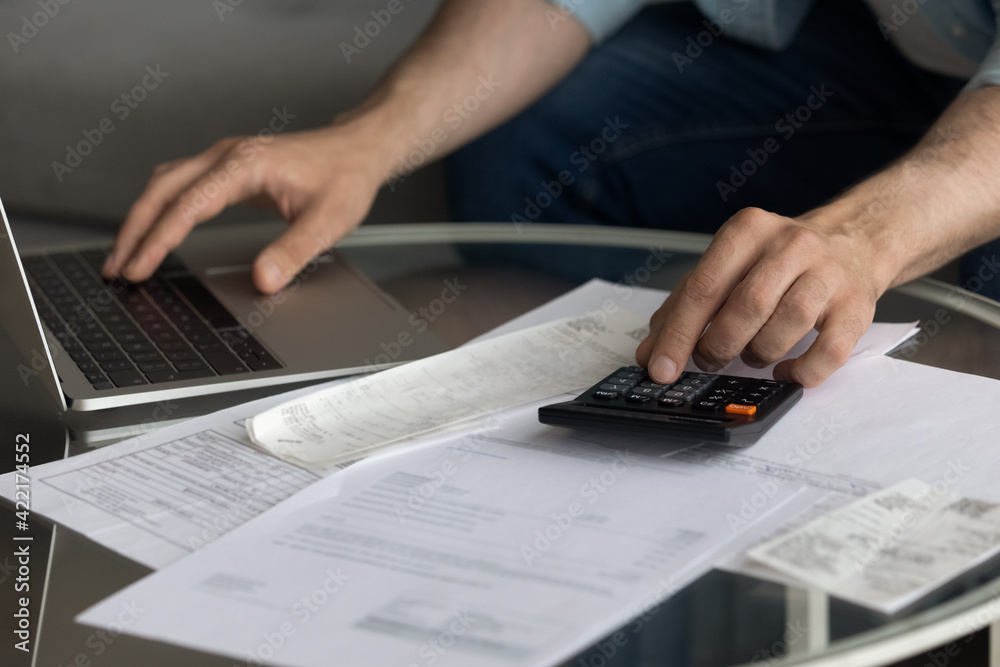 Close up man using calculator and laptop, calculating domestic bills ...