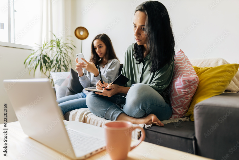 Single Mother Working From Home With Preteen Daughter Around Stock