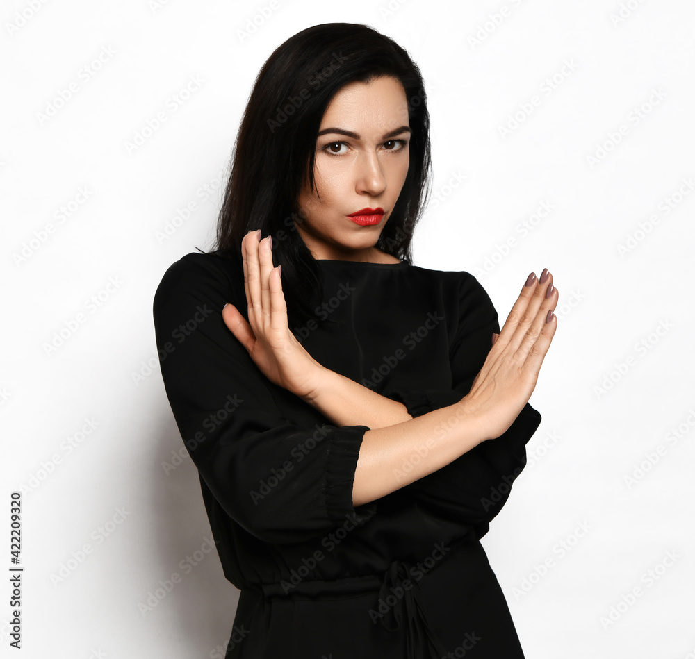 Stern, severe-looking pretty brunette woman in stylish casual black ...