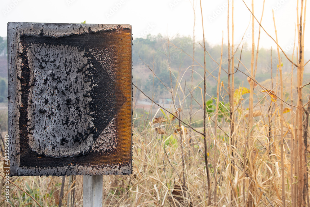 The traffic signs were burned by a wildfire. Environmental forest fire ...