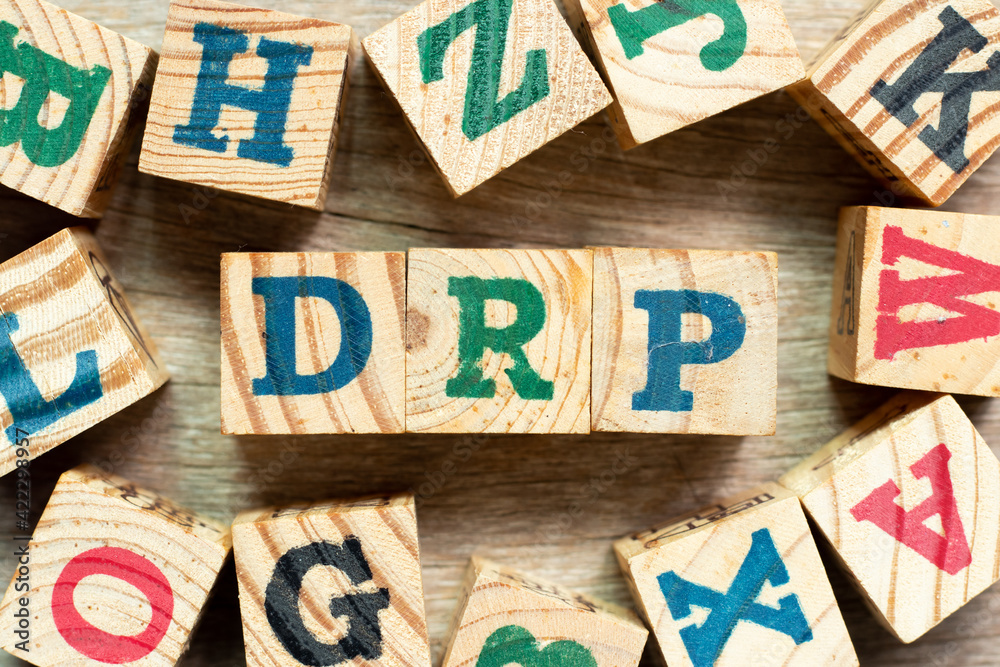 Alphabet letter block in word DRP with another on wood background Stock ...