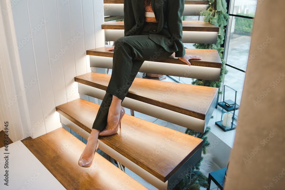 Elegant beautiful legs of the girl. illuminated wooden staircase ...