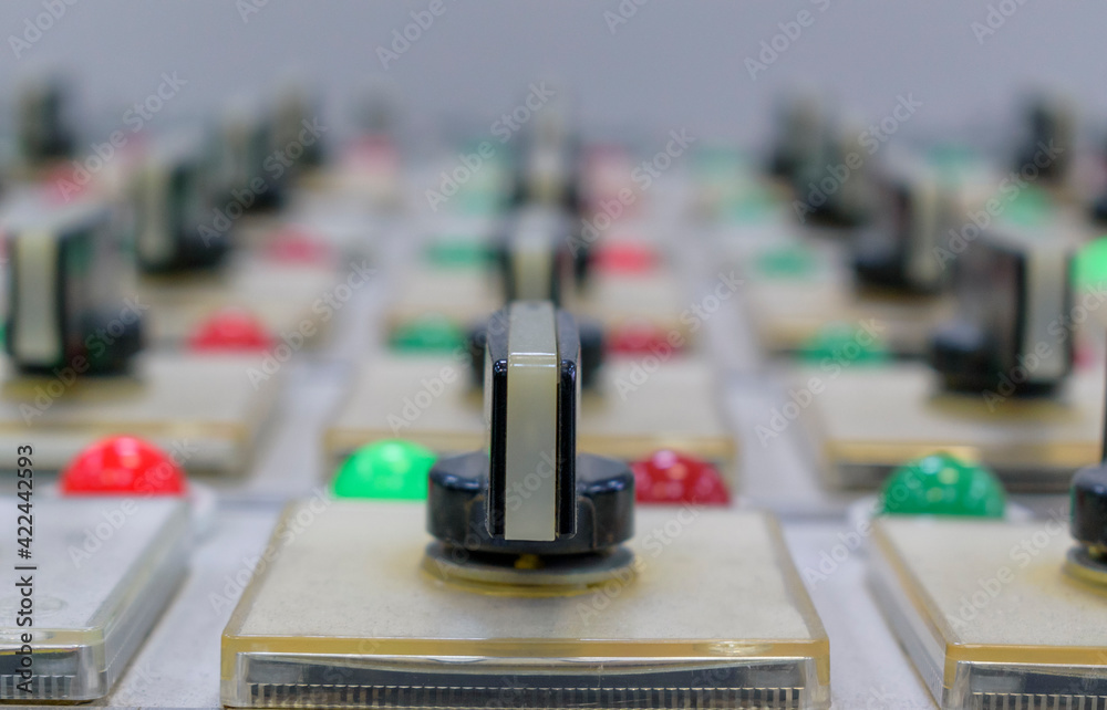Control panel with rows of rotary switches and green and red lamps ...