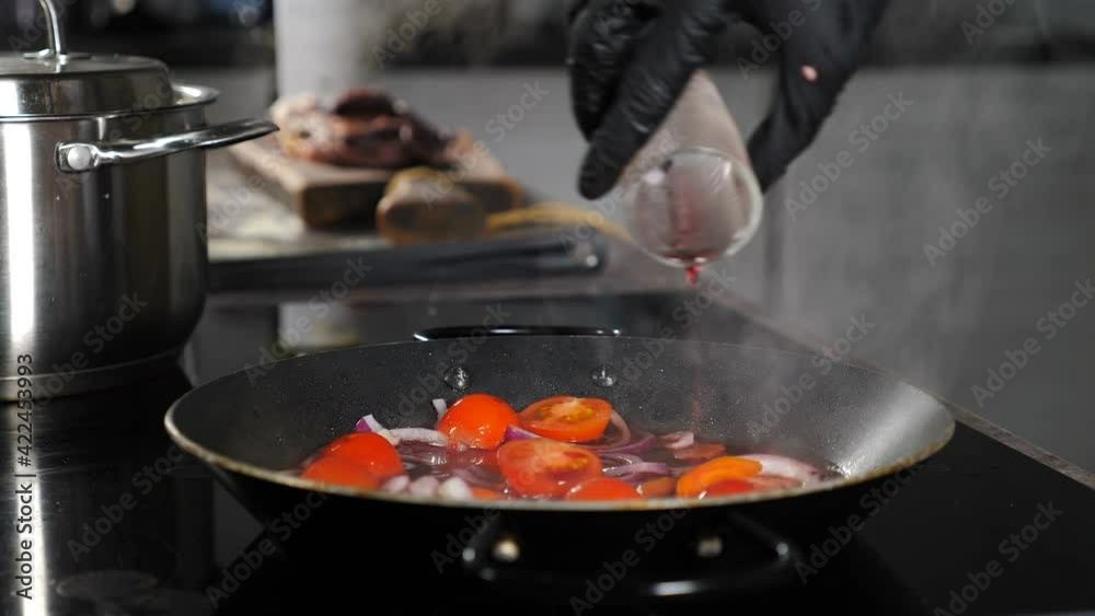 Chef cooking gourmet dish, pouring red wine in frying pan. Delicious ...